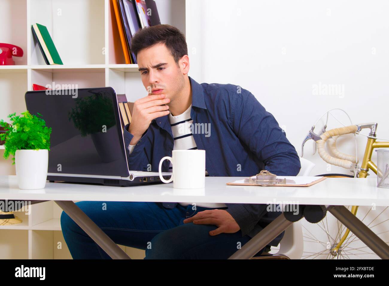 man watching the computer laptop with expression thoughtful Stock Photo ...