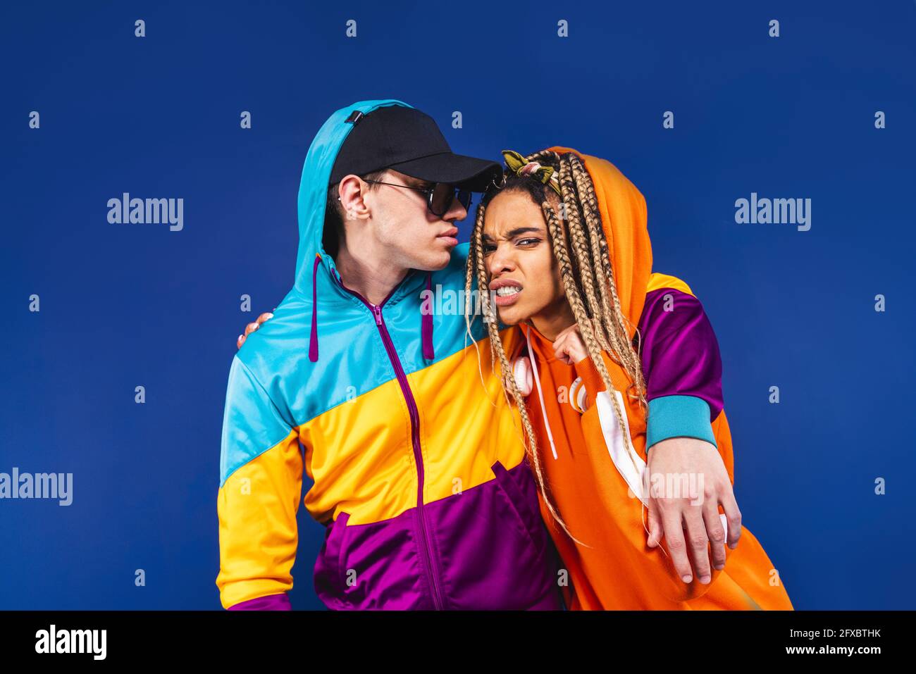 Woman showing uncomfortable gesture for friend standing with arm around ...