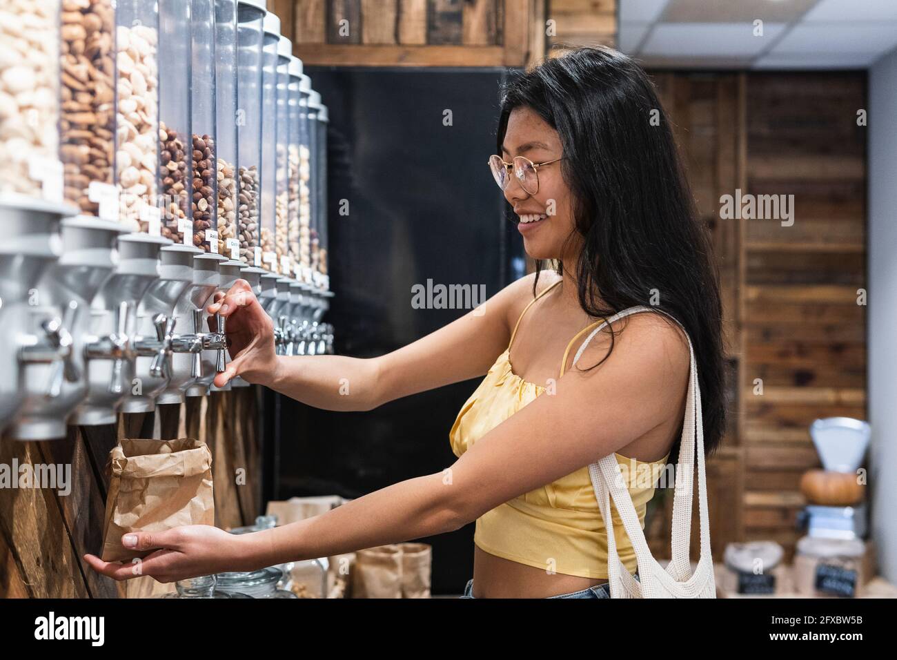 Young woman buying nuts at grocery store Stock Photo - Alamy