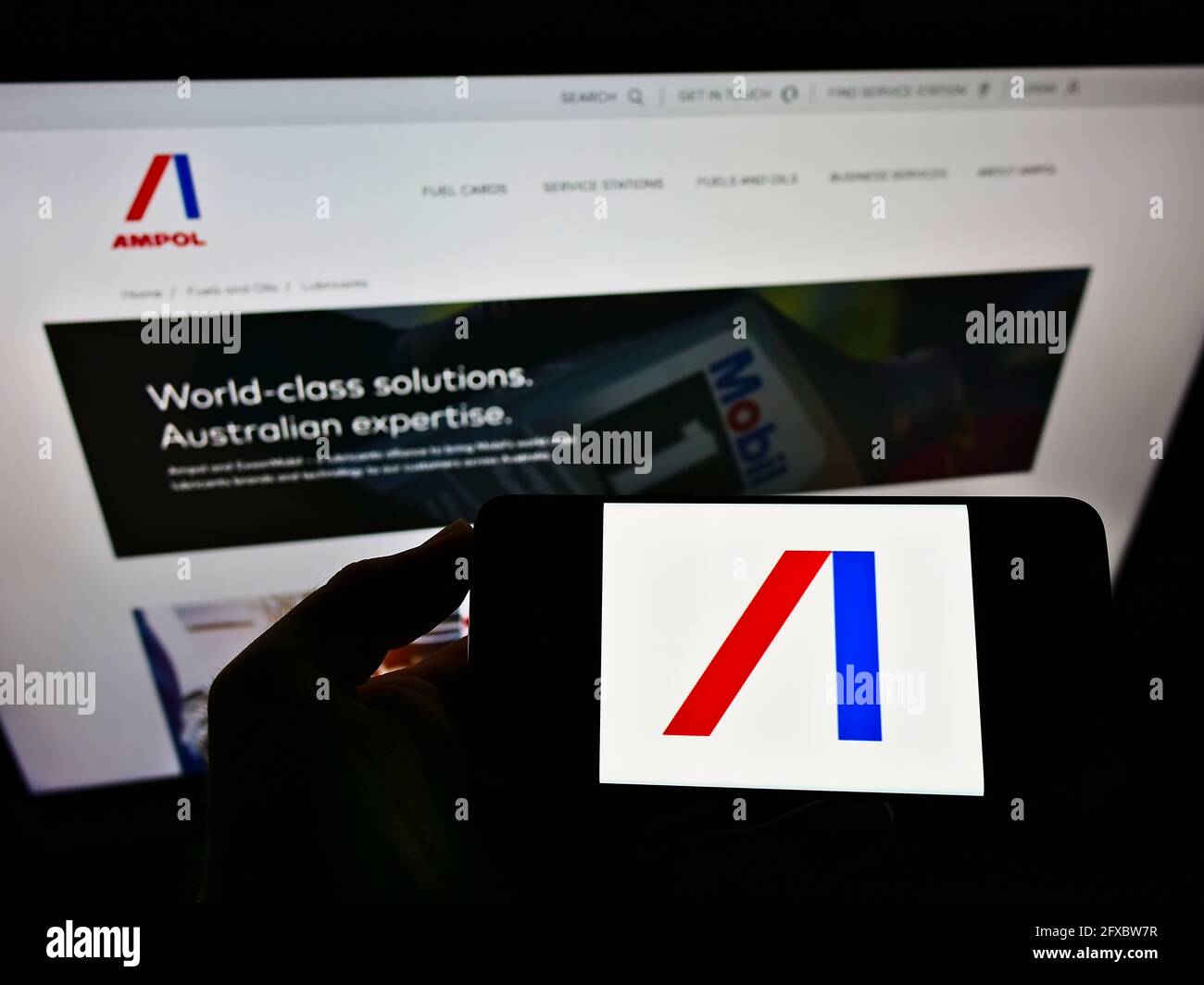 Person holding mobile phone with logo of Australian oil, fuel and gas ...