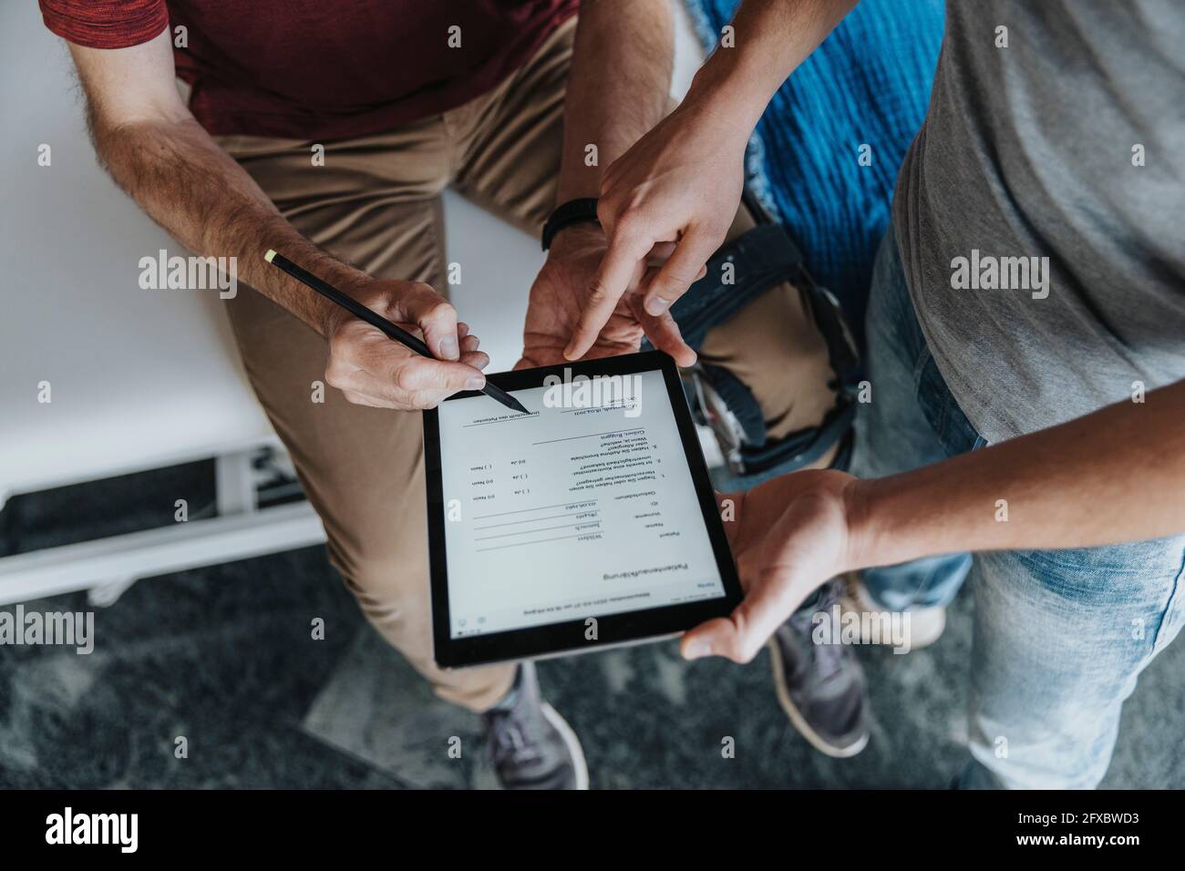 Patient digitally signing form by physiotherapist in practice Stock ...