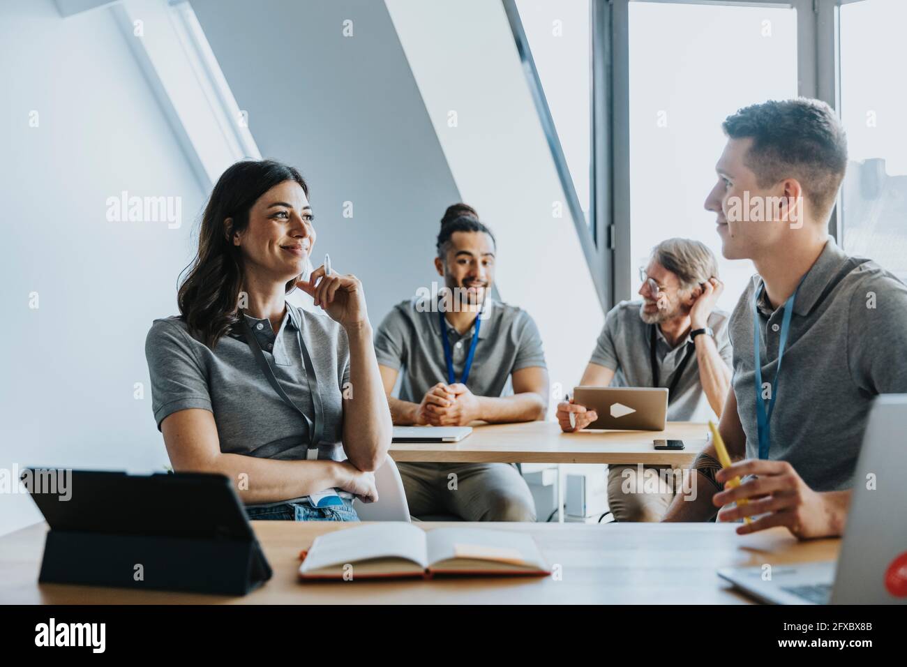 Male and female trainees smiling while discussing in classroom Stock ...