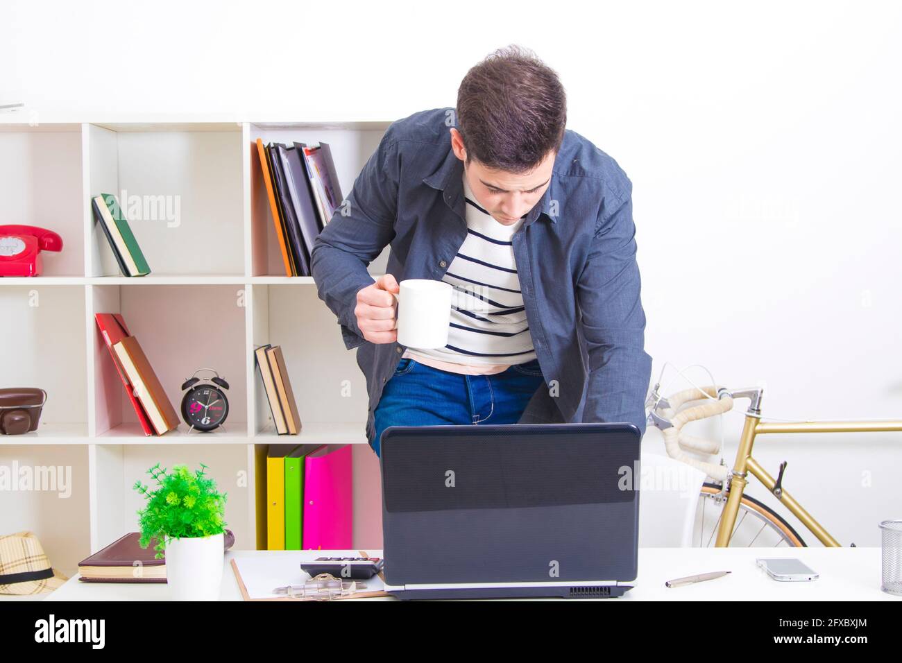 man typing of foot in the computer laptop with the cup of coffee in ...