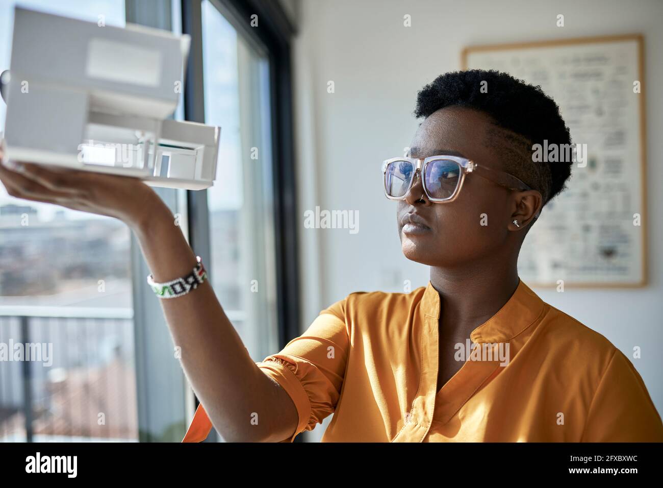Female architect looking at architectural model in office Stock Photo ...