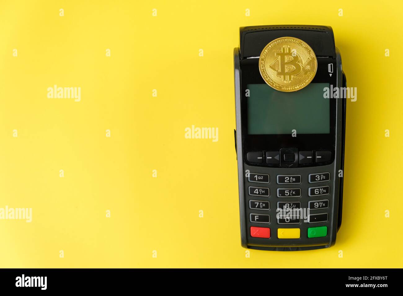 Bitcoin coins on the payment terminal on the yellow background Stock ...