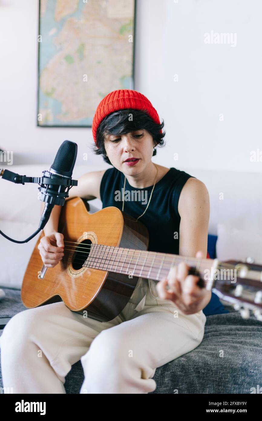 Female singer singing while playing guitar in studio Stock Photo - Alamy