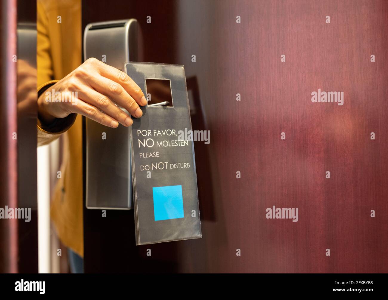 Woman holding do not disturb sign label at hotel door Stock Photo - Alamy