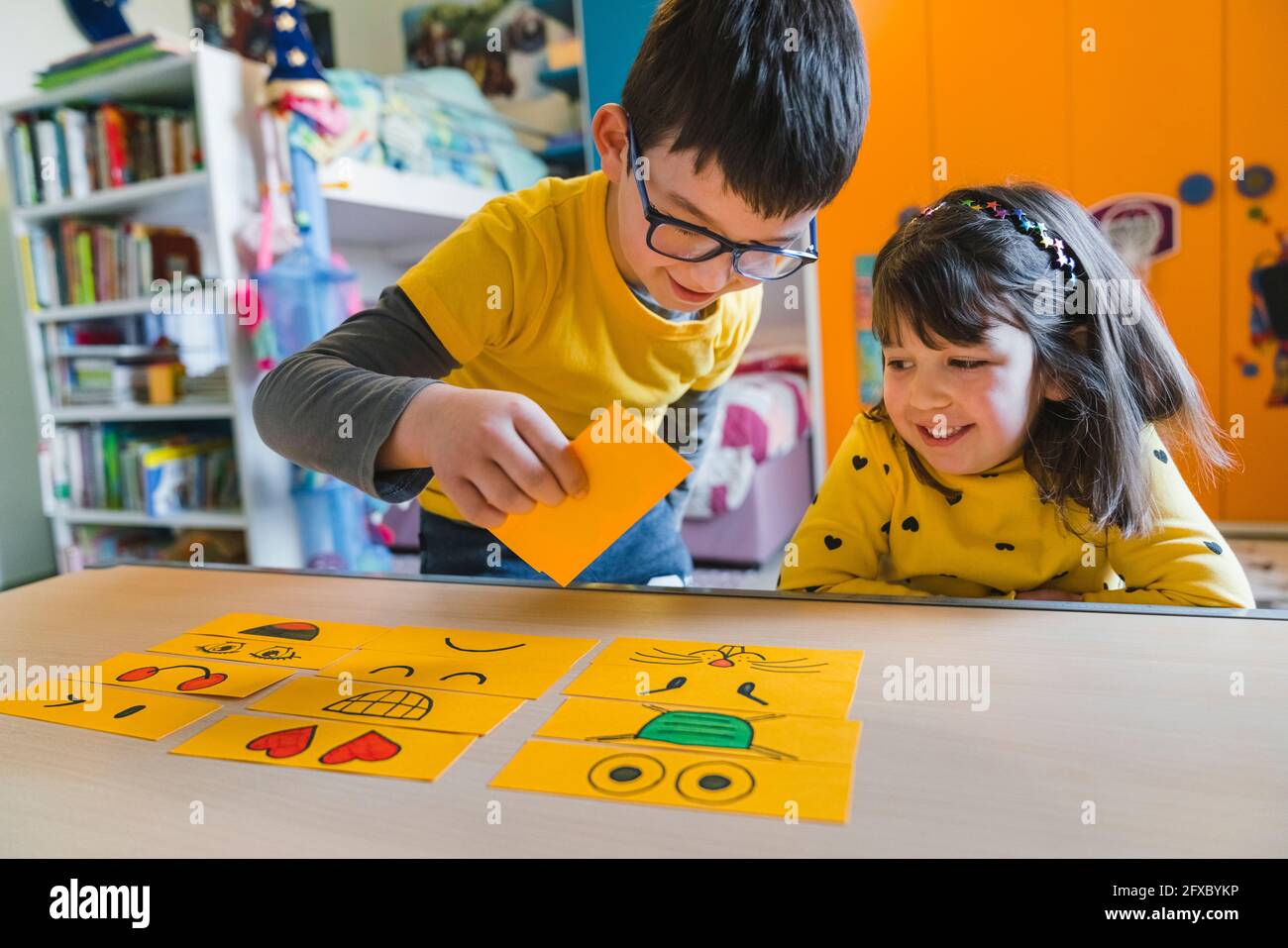 Playful kids with emoticons on table in playroom at home Stock Photo ...