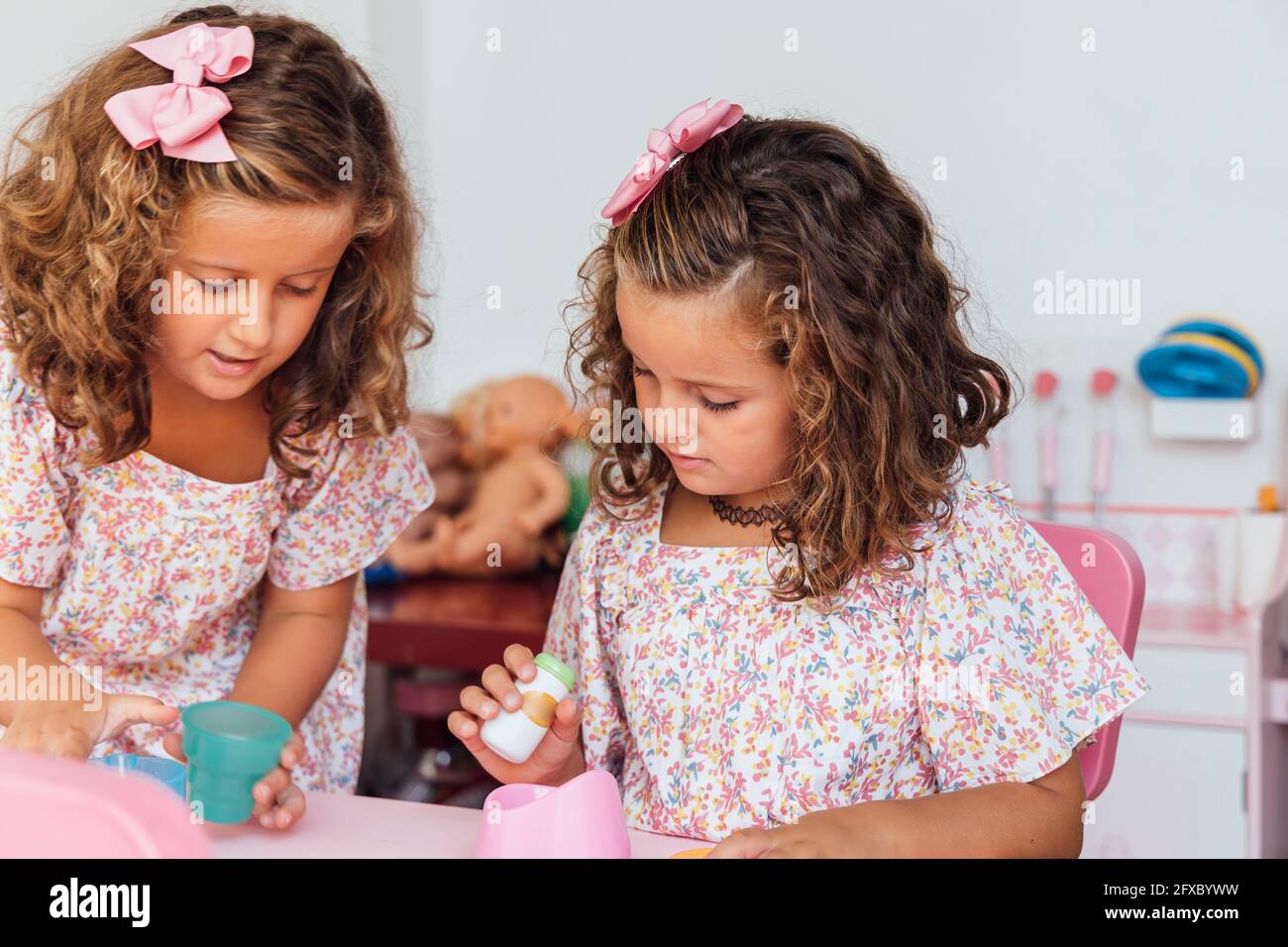 Twin sisters playing with toys at home Stock Photo - Alamy