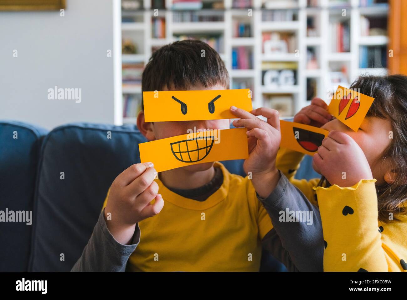 Girl and boy playing with emoticons at home Stock Photo - Alamy