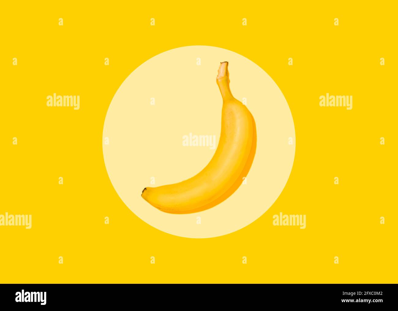 Studio shot of single banana lying against yellow background Stock ...