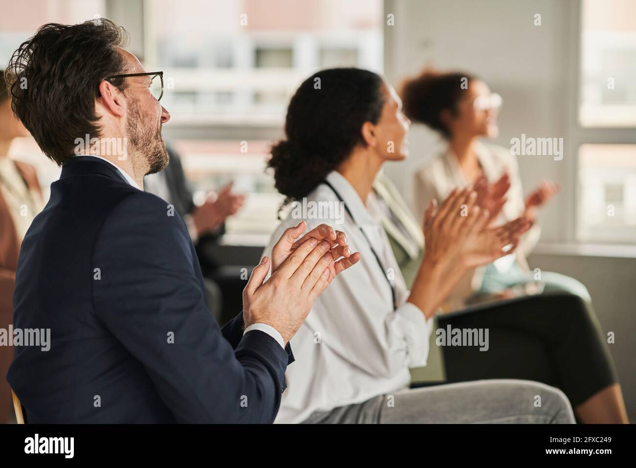 Businessman clapping hands with colleagues in conference event Stock ...