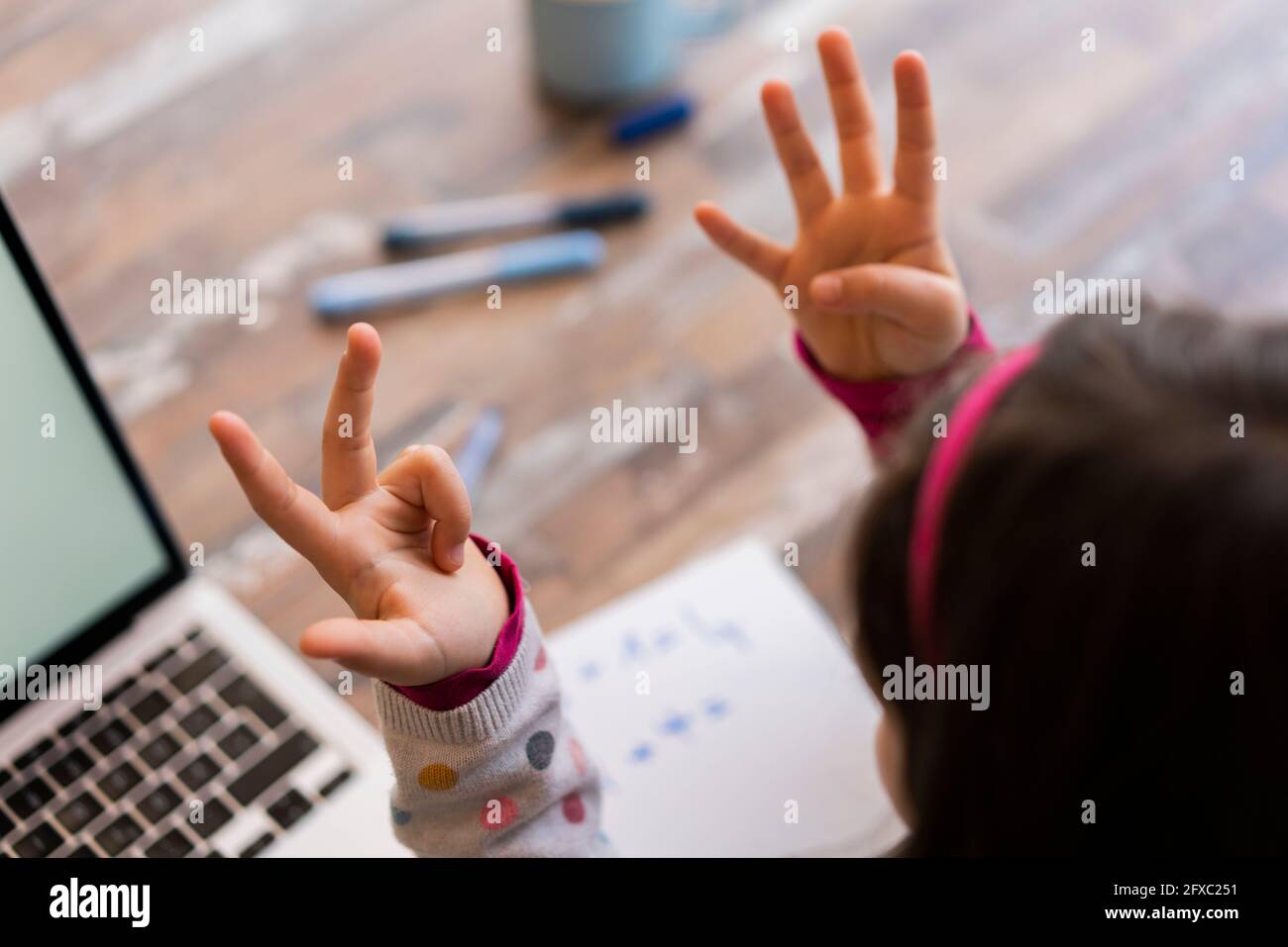 Girl counting fingers while studying at home Stock Photo - Alamy