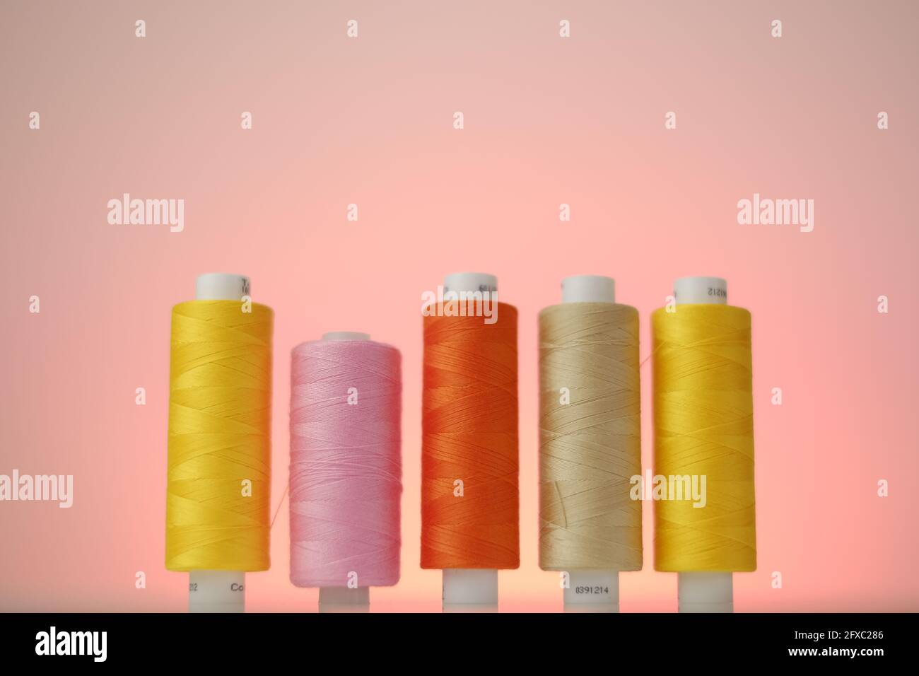 Sewing threads.Multicolored threads set. Yellow, orange and pink ...