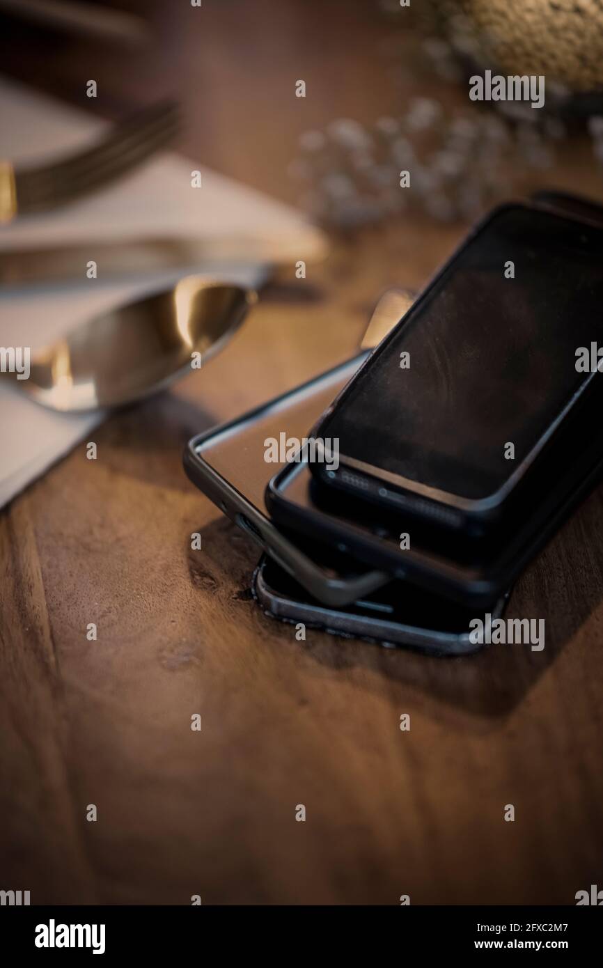 Smart phone stacked on dining table at home Stock Photo - Alamy