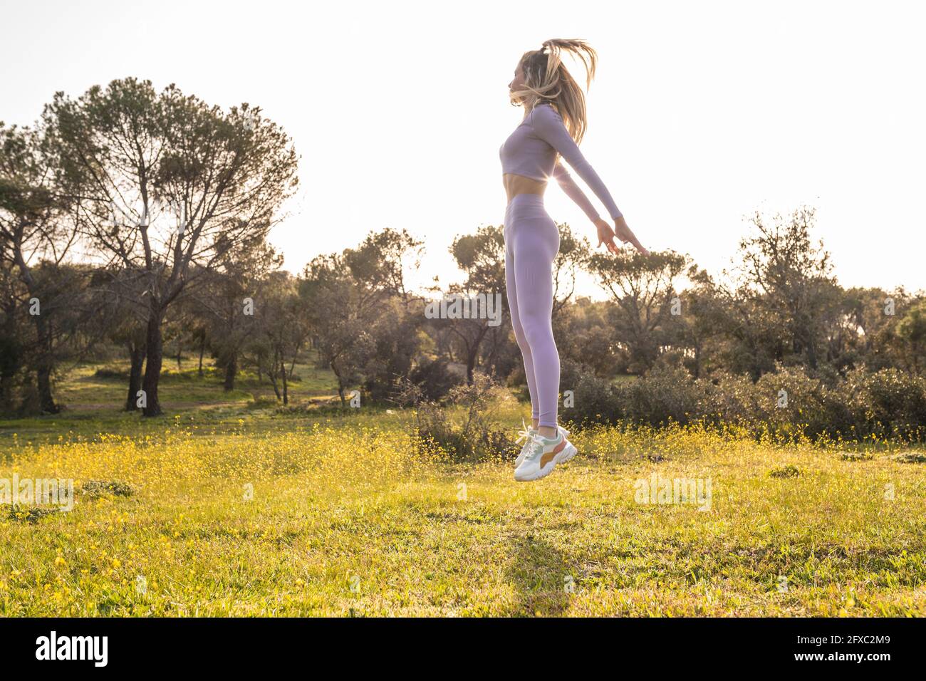 Female athlete jumping while exercising at grass area Stock Photo - Alamy