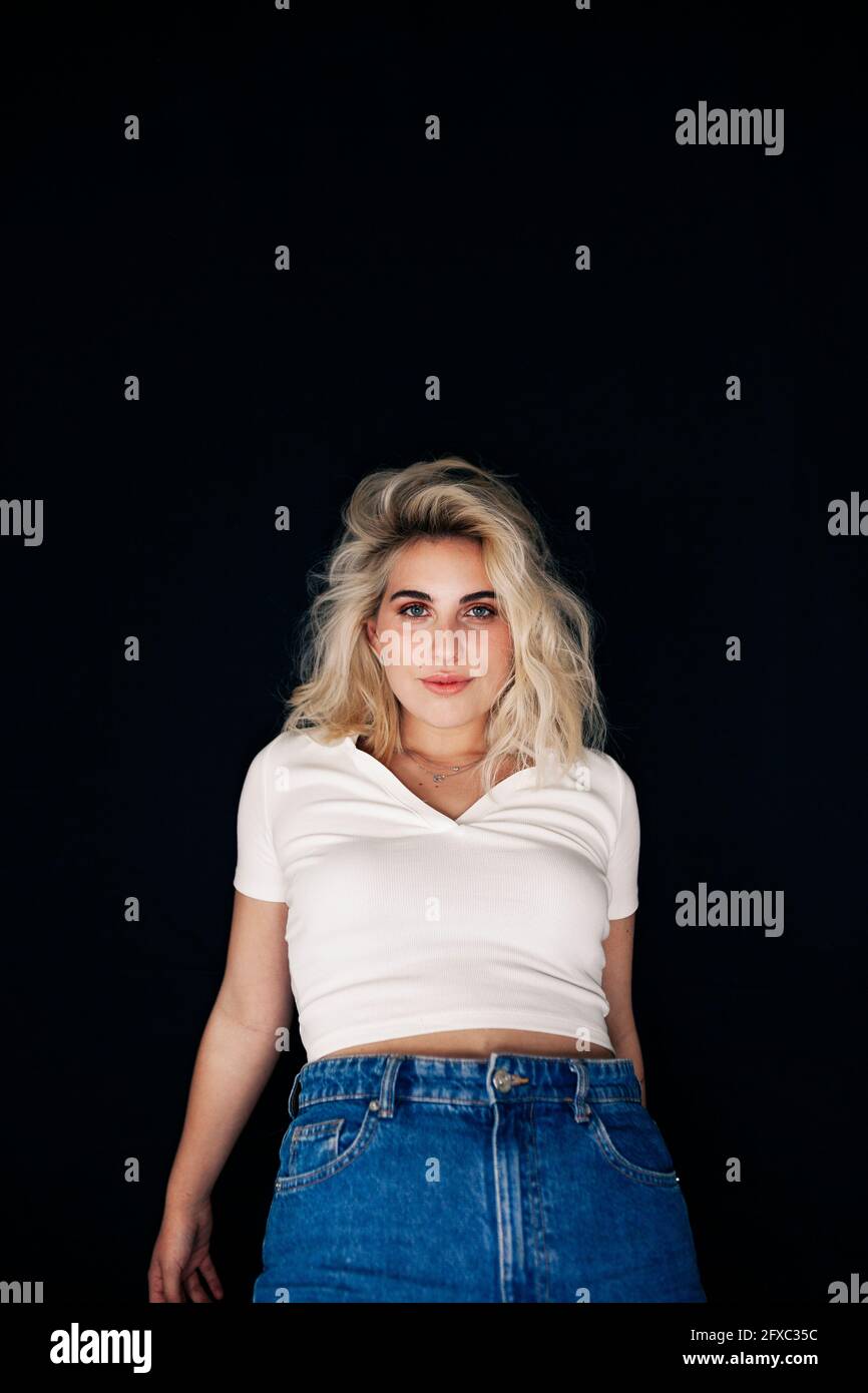 Beautiful woman leaning in front of black background Stock Photo - Alamy