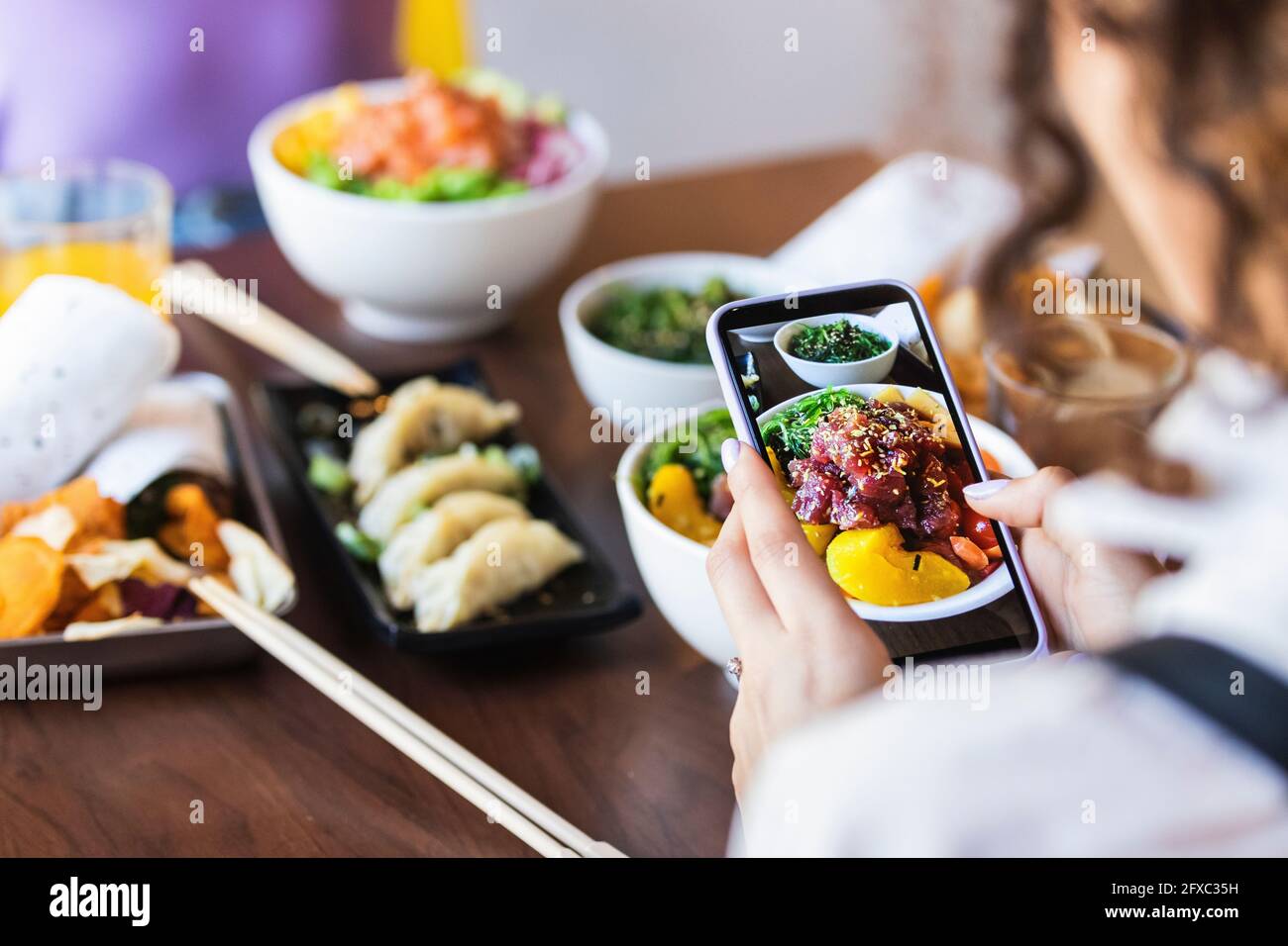 Woman photographing food through mobile phone in restaurant Stock Photo ...