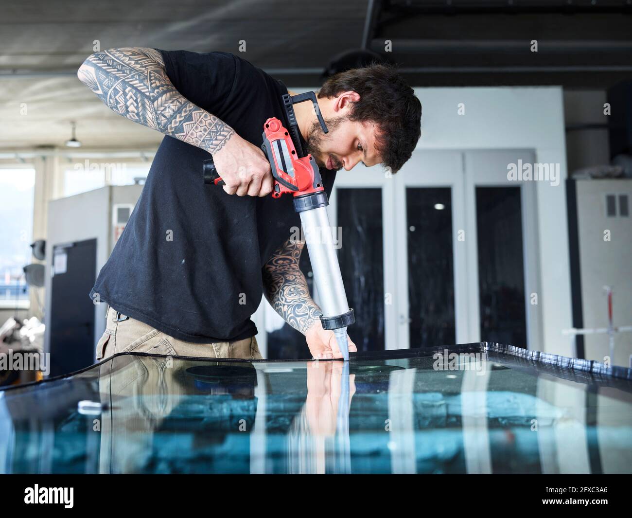 Male glazier with equipment working on glass at garage Stock Photo - Alamy