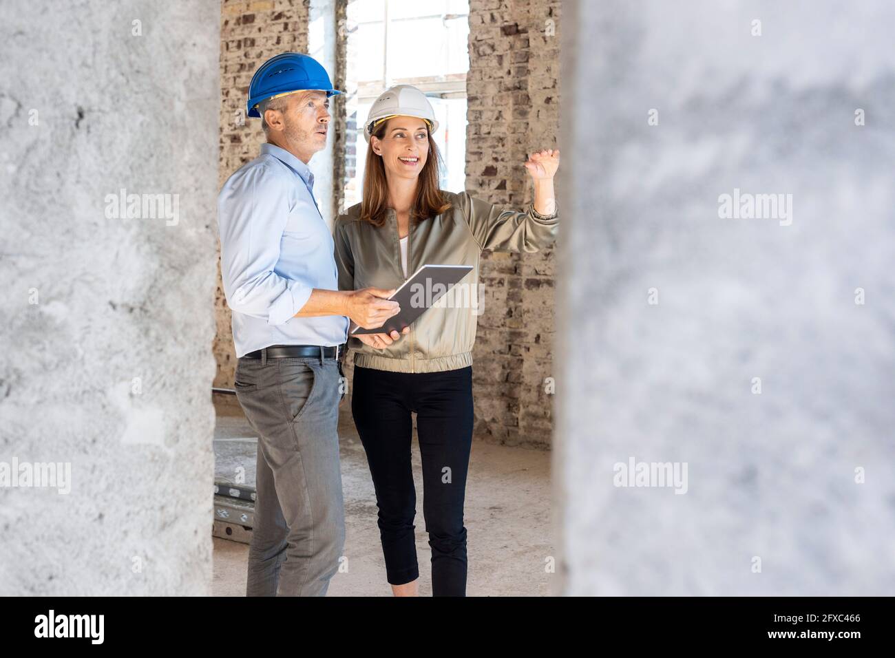 Female client gesturing while discussing with male architect at ...