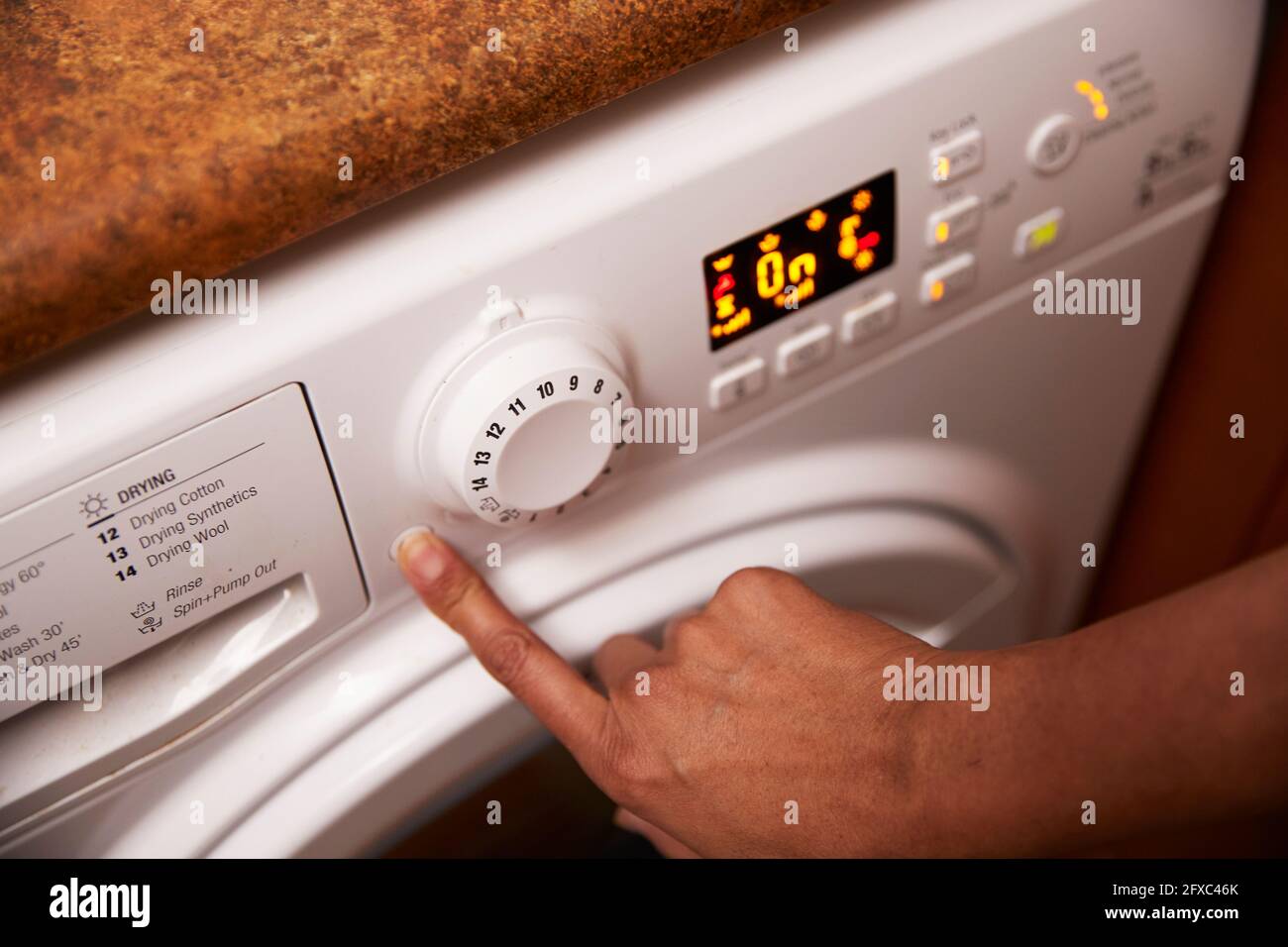 Woman operating washing machine at home Stock Photo - Alamy