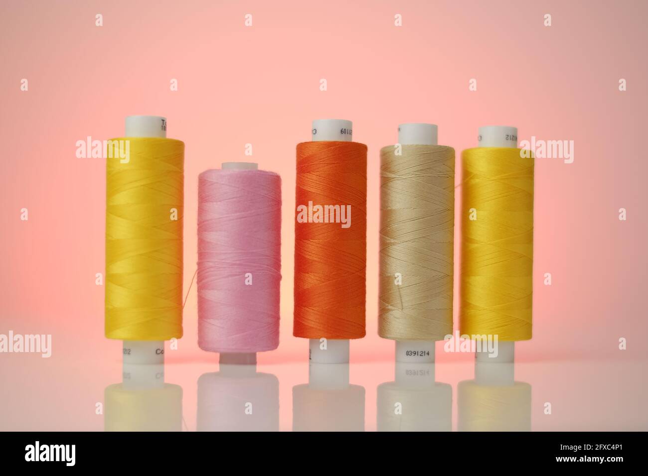 Sewing threads.Multicolored threads set. Yellow, orange and pink ...