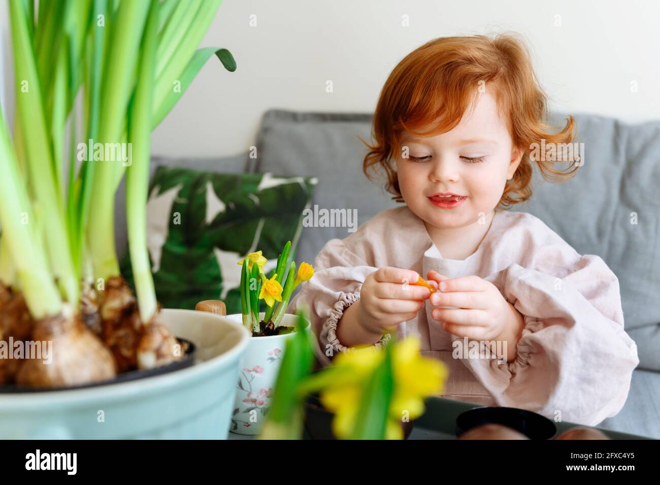 Curious girl playing on sofa at home Stock Photo - Alamy