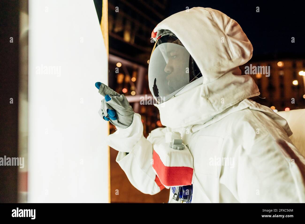 Male astronaut pointing on illuminated wall Stock Photo - Alamy