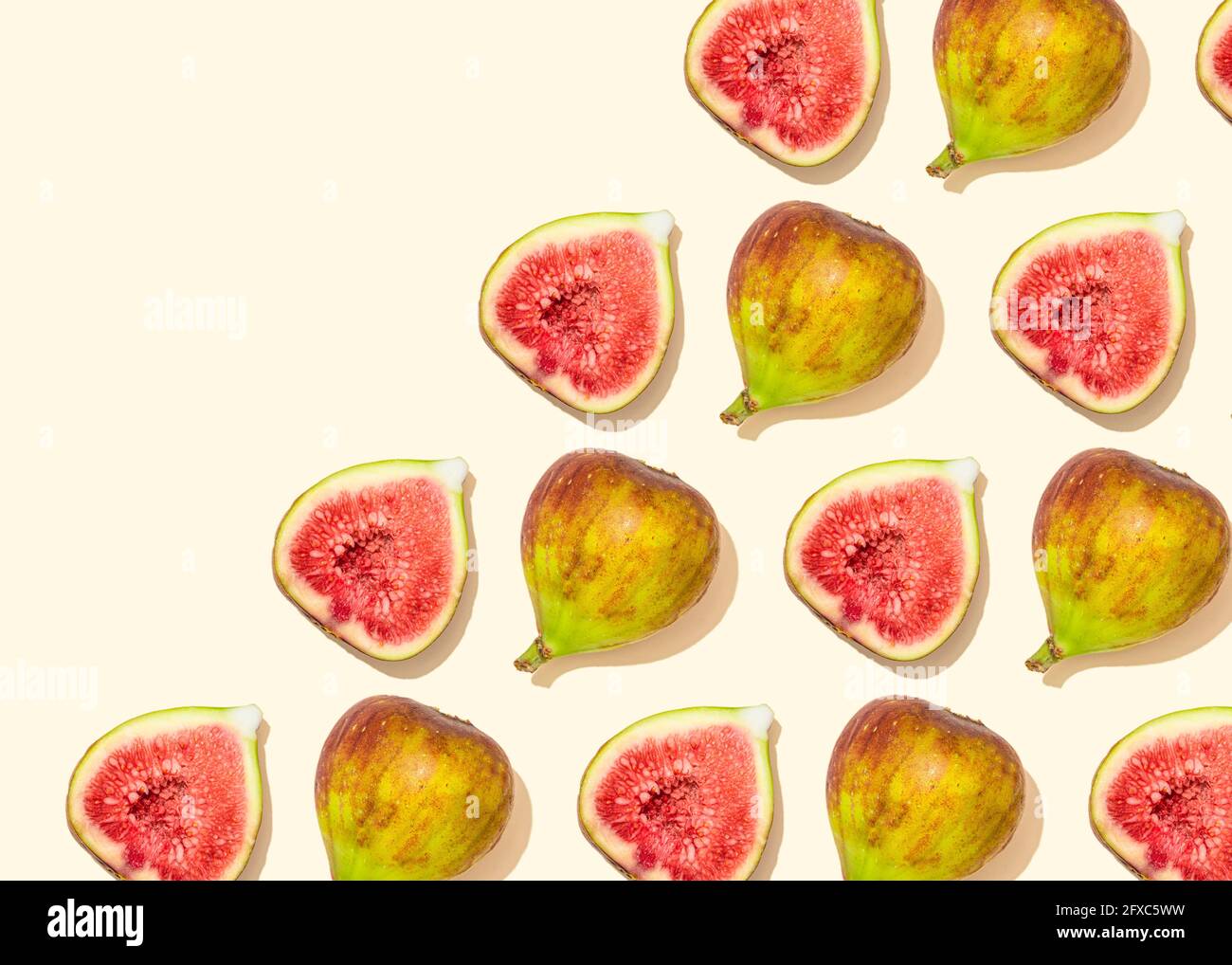 Pattern of halved figs flat laid against light yellow background Stock ...