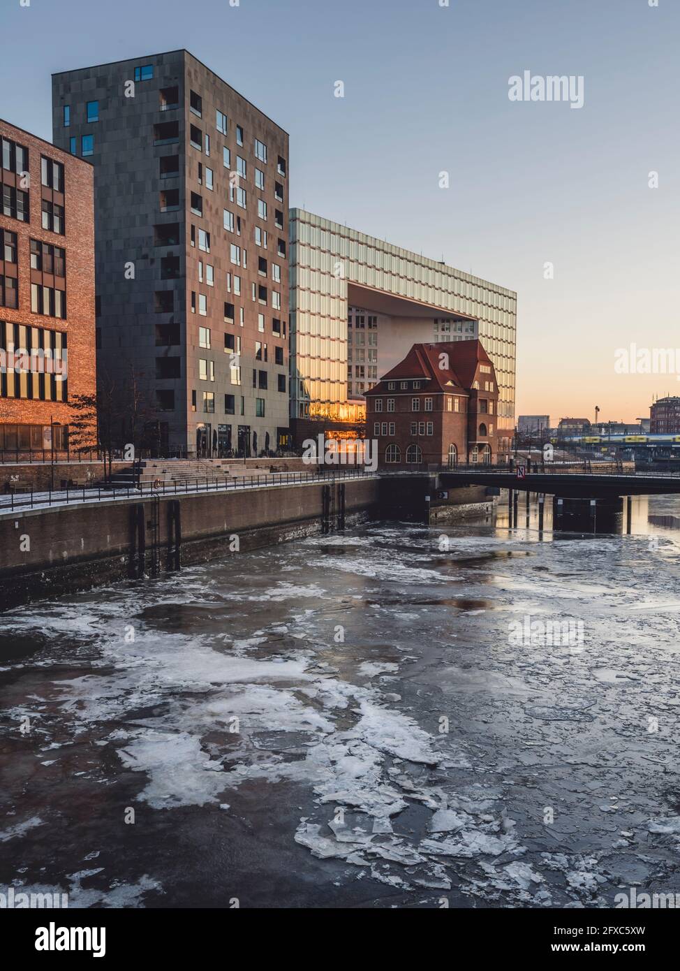 Germany, Hamburg, Frozen waters of Brooktorhafen at dusk in winter ...