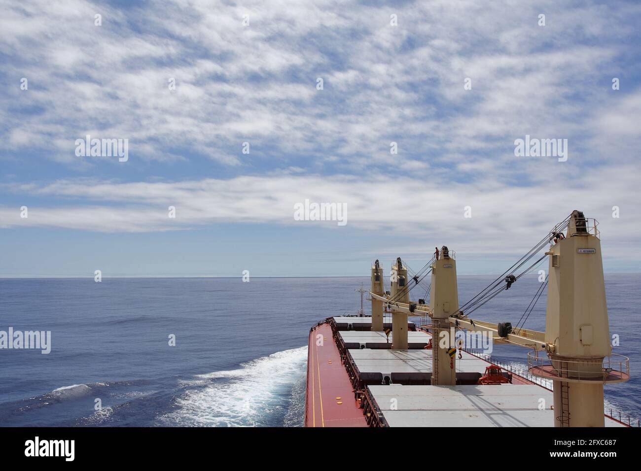 Maintenance work never ends on board. Deck crew lubricate crane wires ...
