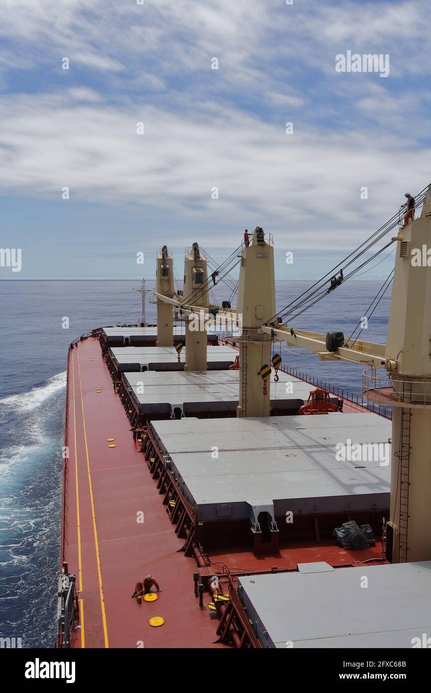 Maintenance work never ends on board. Deck crew lubricate crane wires ...