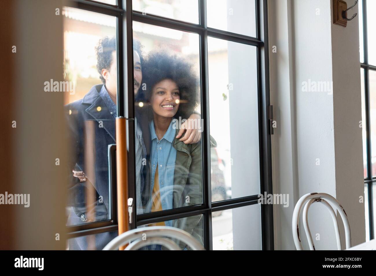 Man with girlfriend looking inside cafe through glass window Stock ...