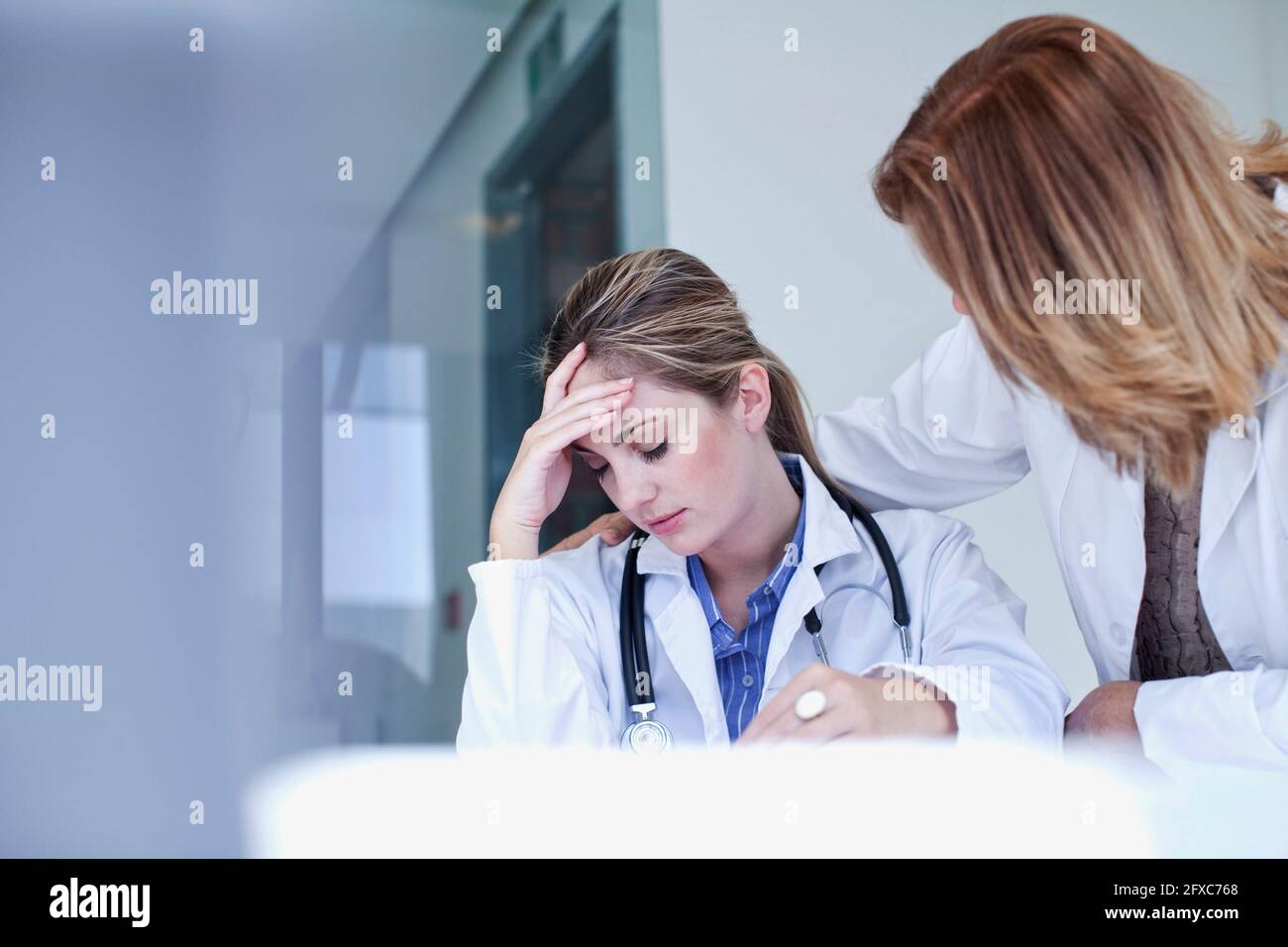 Female doctor consoling sad colleague in hospital Stock Photo - Alamy