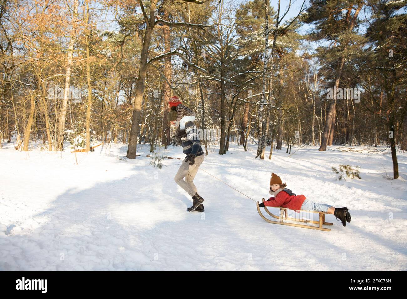 Playful father with sons in snow during winter Stock Photo - Alamy