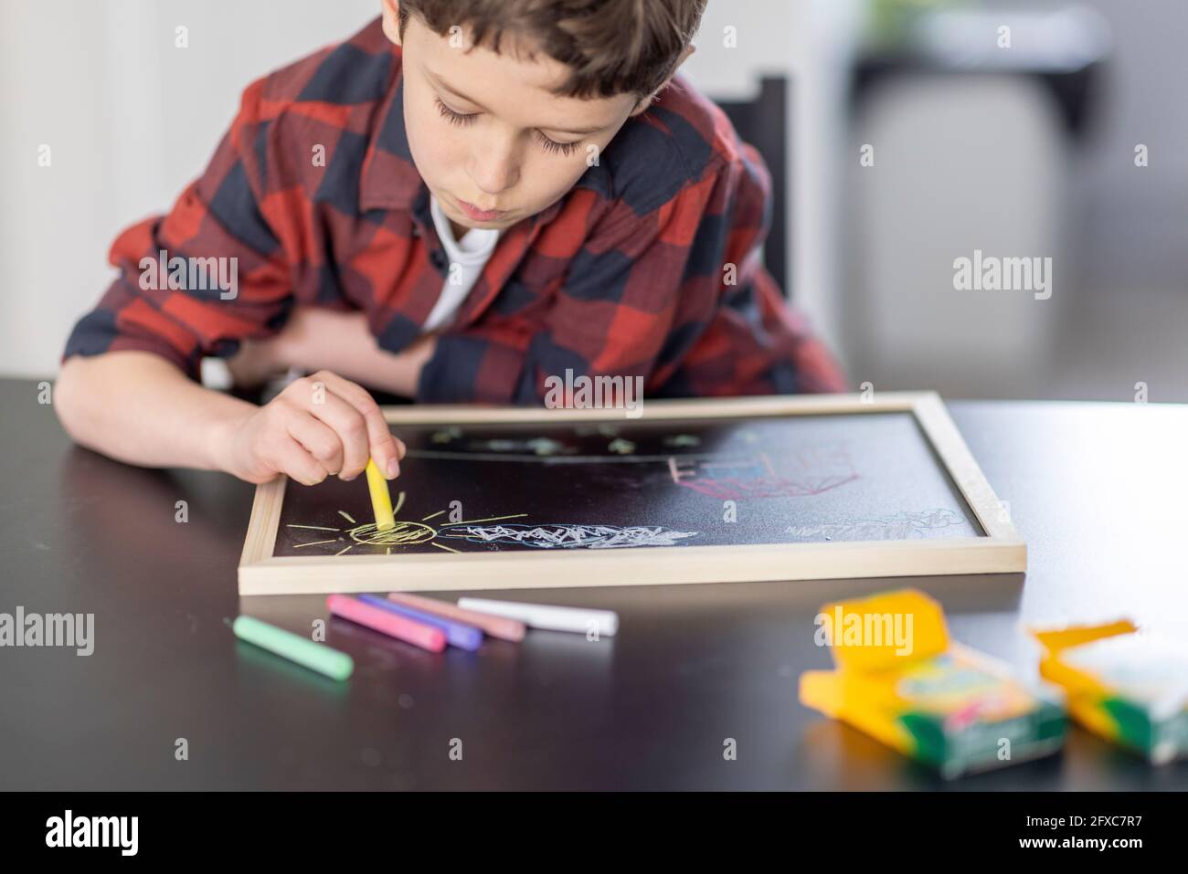 Boy drawing with colorful chalks on slate at home Stock Photo - Alamy