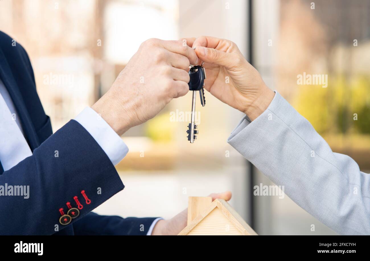 Mature real estate agent giving house keys to female entrepreneur Stock ...