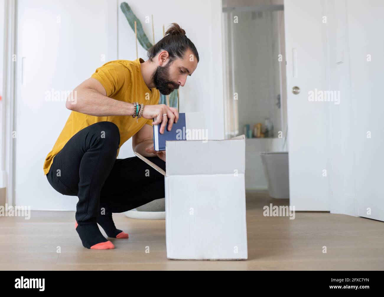 Man keeping book in cardboard box at home Stock Photo - Alamy