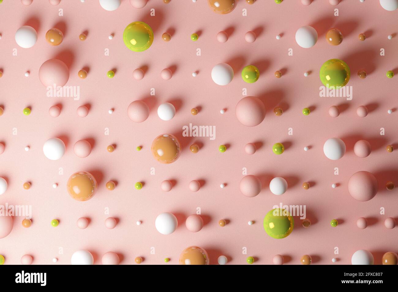 Three dimensional pattern of various spheres flat laid against pink ...