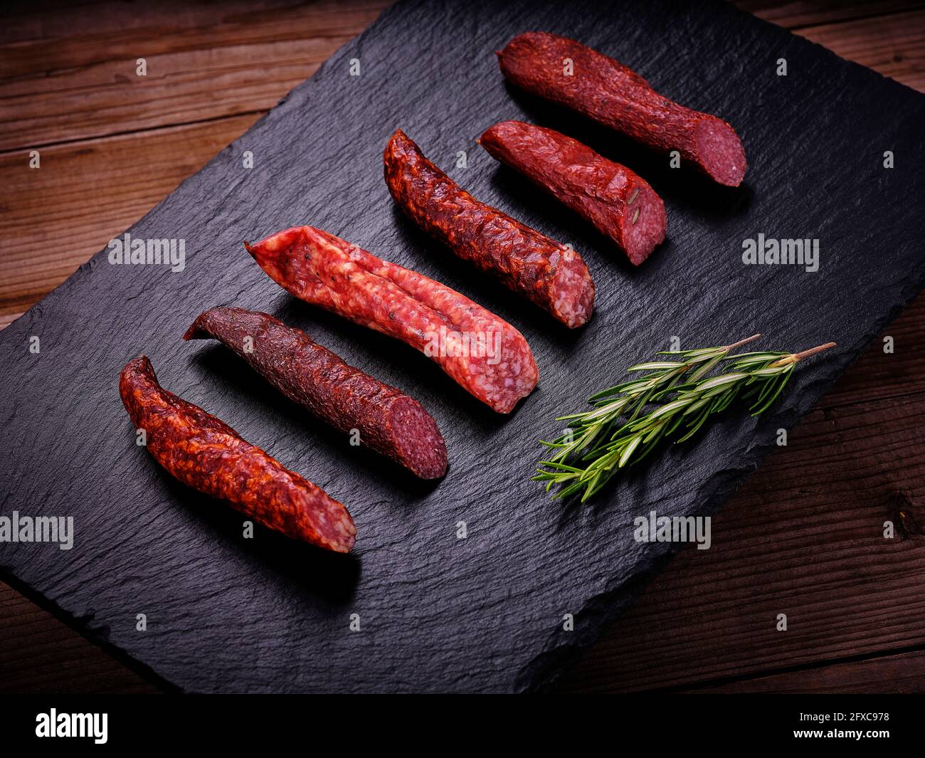 Landjager sausage with rosemary on black slate stone slab Stock Photo ...