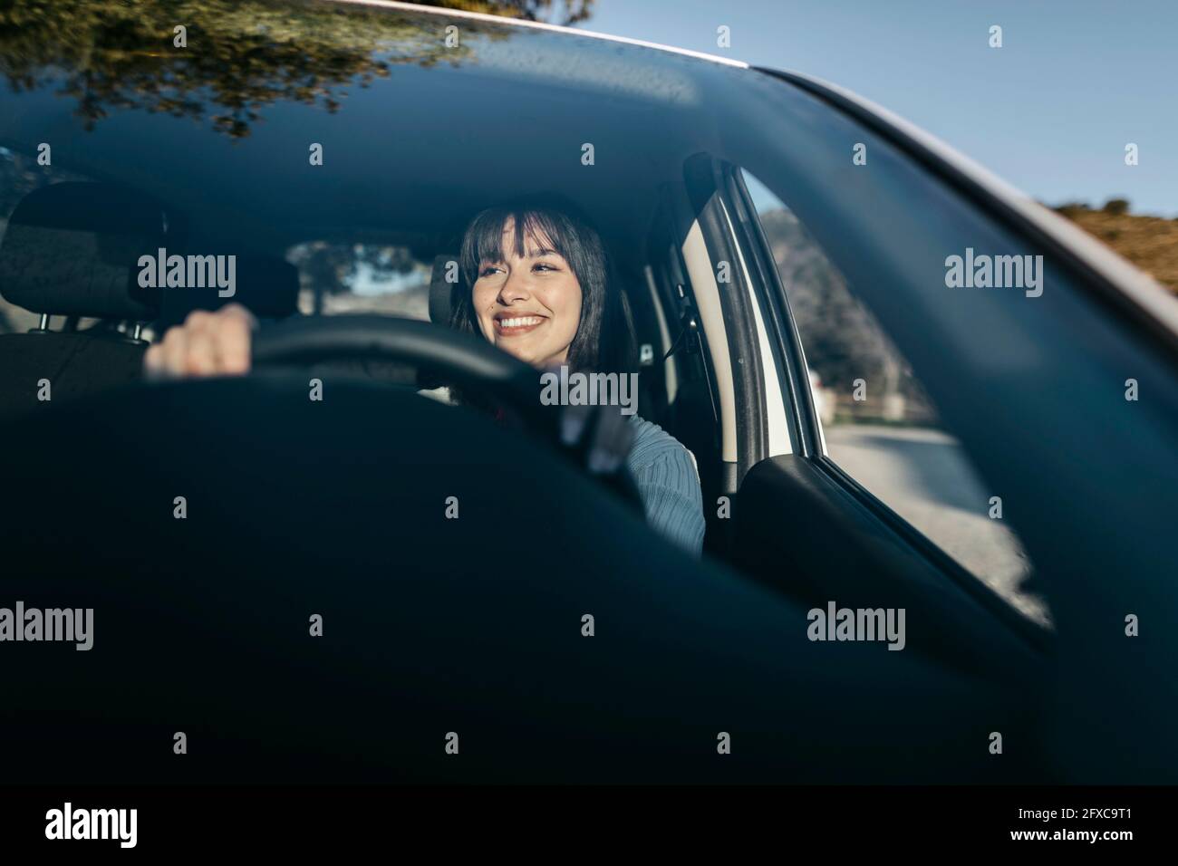 Young woman driving car seen through windshield Stock Photo - Alamy