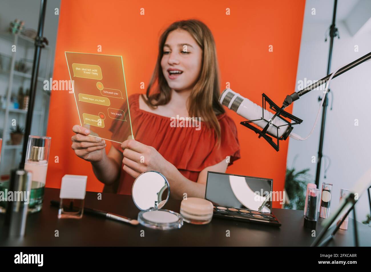 Teenage female influencer reading online feedback on futuristic digital ...