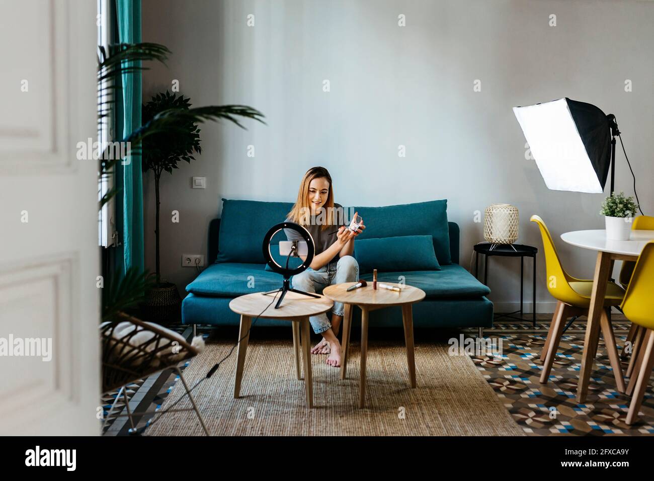 Female influencer filming tutorial through mobile phone at home Stock ...