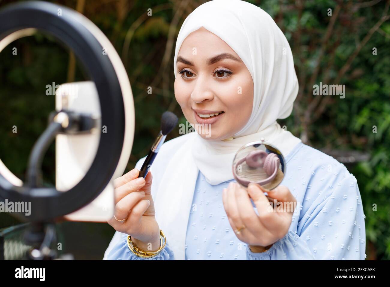 Beautiful female influencer wearing hijab vlogging Stock Photo - Alamy