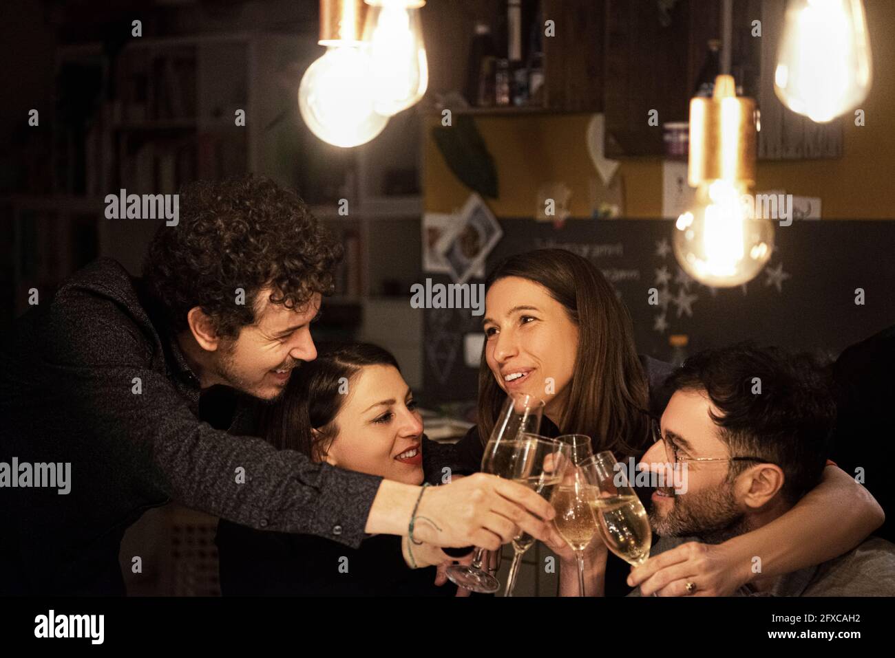 Happy male and female friends raising toast during birthday celebration ...