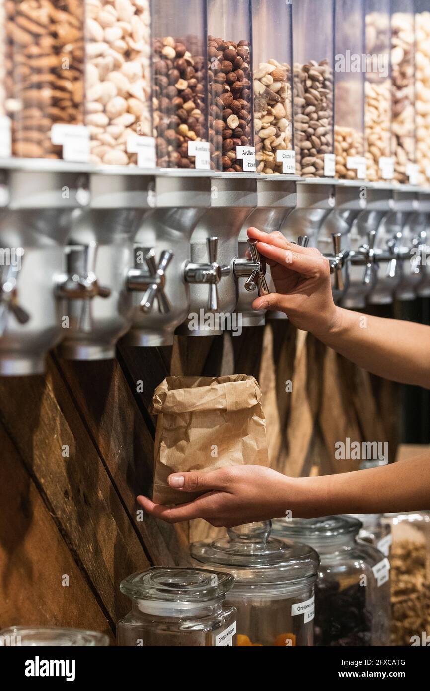 Woman buying nuts in jar at supermarket Stock Photo - Alamy