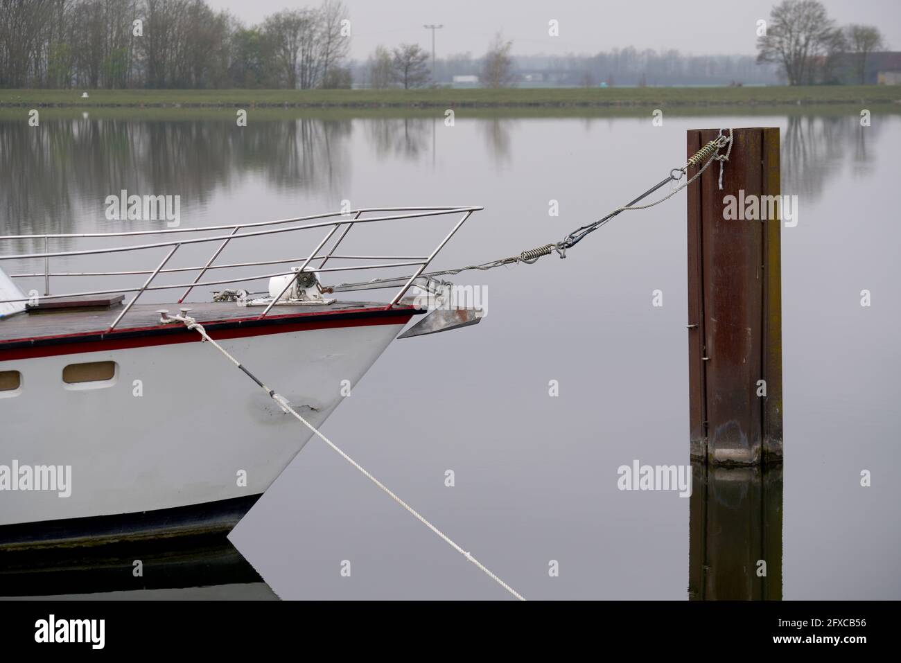 Boat attached to bollard by mooring rope Stock Photo - Alamy