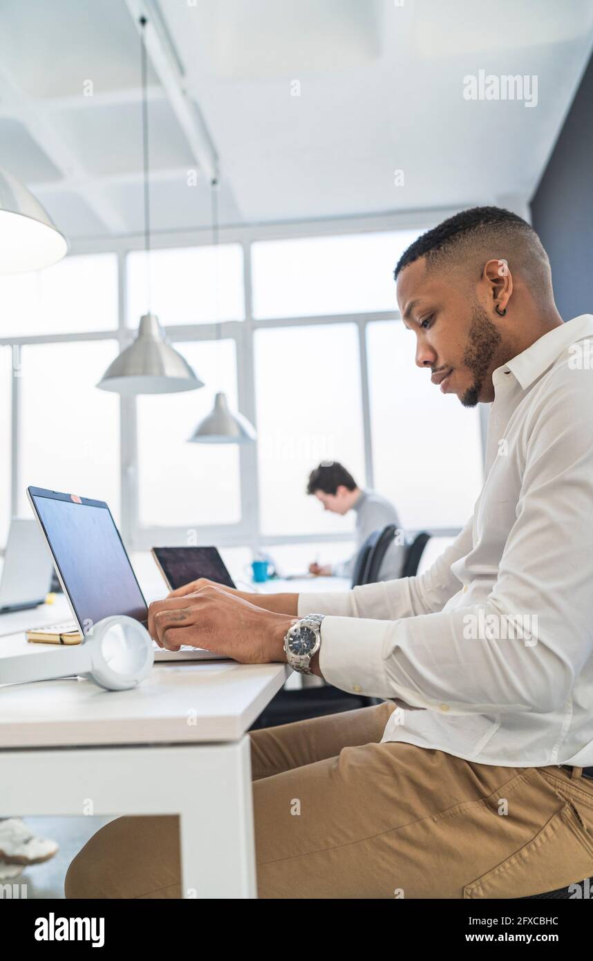 Male entrepreneur using laptop at office Stock Photo - Alamy