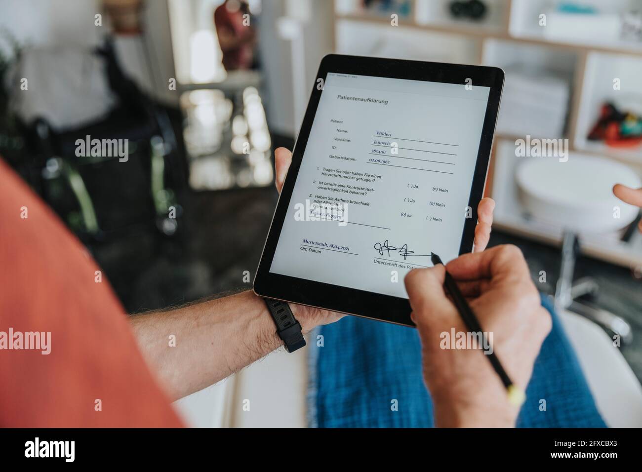 Male patient digitally signing form in practice Stock Photo - Alamy