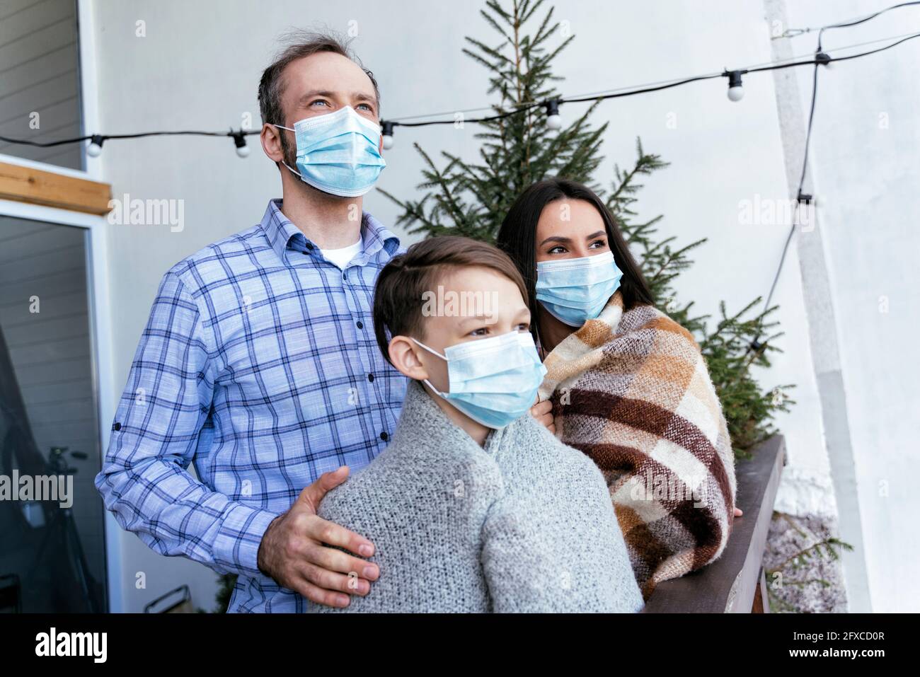 Family of three standing in masks hi-res stock photography and images ...